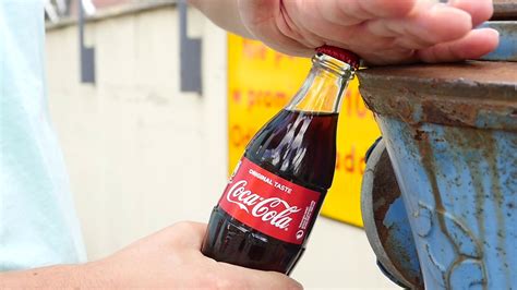 Man Opens A Bottle Of Coca Cola Soda Drink On A Street Stock Video