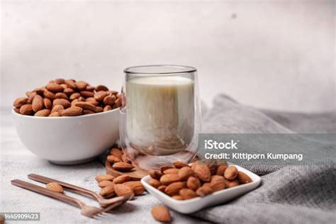 흰색 콘크리트 배경에 아몬드 씨앗이 있는 아몬드 우유 한 잔 0명에 대한 스톡 사진 및 기타 이미지 0명 갈색 건강관리와