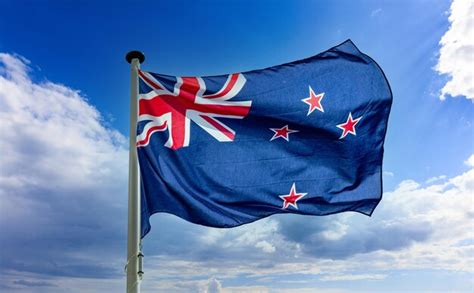 Premium Photo New Zealand Flag Waving Against Blue Cloudy Sky