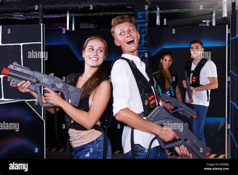 Guy And Girl Are Happy With Their Victory In Laser Tag Game In Dark Laser Tag Room Stock Photo