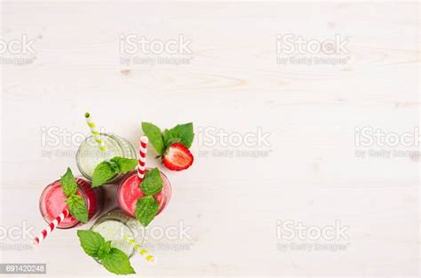 짚으로 유리 항아리에 갓 혼합된 녹색과 빨간색 과일 스무디 민트 잎 상위 보기 화이트 나무 보드 배경 공간을 복사 합니다 0명에