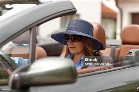 갈색 긴 머리와 파란색 블라우스와 성숙한 여자는 자동차 운전에 앉아있다 50 54세에 대한 스톡 사진 및 기타 이미지 50