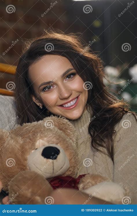Cute Girl In Knee Socks And Sweater With Teddy Bear In Her Hands