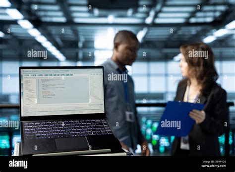 Close Up Of Code Lines On Laptop Screen In Front Of Data Center