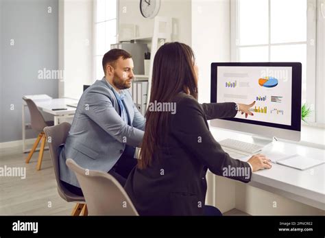 Two Businesspeople Analyzing Data Charts Graphs On Pc Monitor Stock