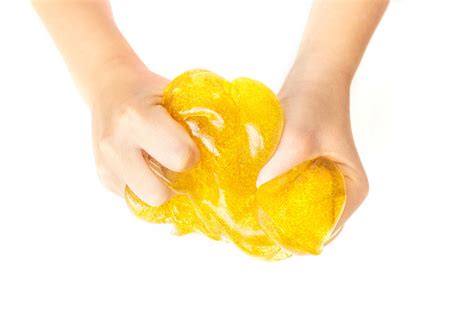 점액이라고 불리는 현대 장난감 아이 재생 투명 노란색 점액 흰색 배경에 고립 된 점액을 들고 손 선택적 초점 Stem 주제에