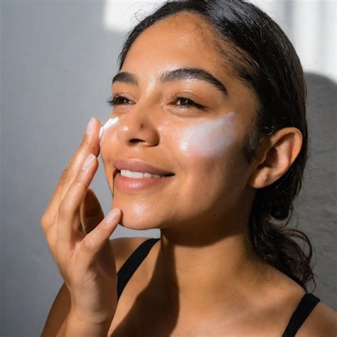 Premium Ai Image A Woman Applying Face Moisturizer To Her Face Her