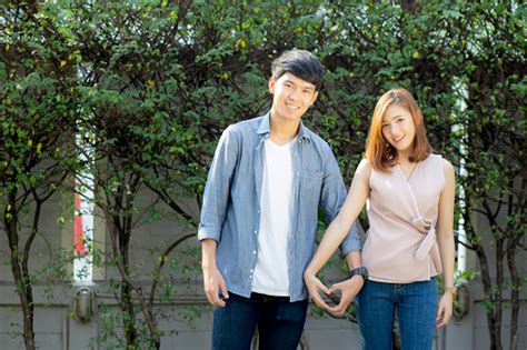 아름 다운 행복 한 젊은 부부는 함께 야외에서 손 남자와 여자 와 관계 느낌 사랑 을 상징 하 고 정원에 기호 연인과 낭만적 인 개념으로 제스처 심장 모양을 만드는 재미