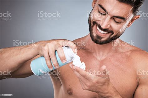 손 면도 크림 제모를 위해 회색 배경에 격리된 스튜디오에 있는 제품을 가진 남자 스킨케어 얼굴 그리고 제모 건강 및 위생을 위해