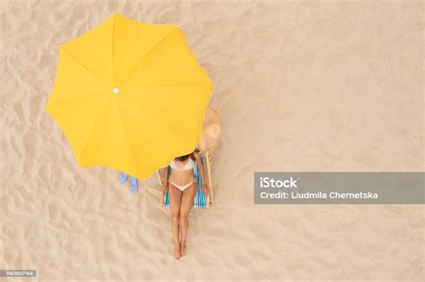 모래 사장에서 노란 해변 우산 아래 햇볕에 쉬고있는 여자 공중 전망 텍스트를 위한 공간 모래에 대한 스톡 사진 및 기타 이미지