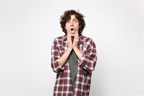 캐주얼에 충격 젊은 남자의 초상화 입을 열어 스튜디오에서 흰색 벽 배경에 고립 된 얼굴에 손을 넣어 사람들은 진심으로 감정