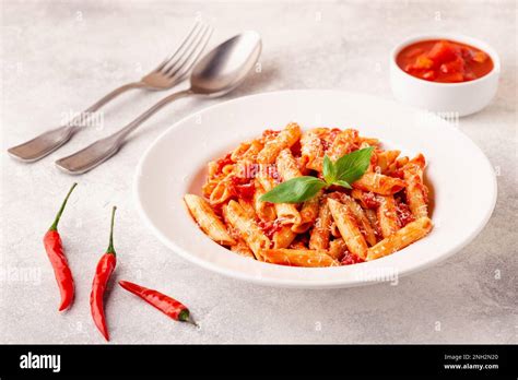 Classic Italian Pasta Penne Alla Arrabiata With Fresh Basil On A Light