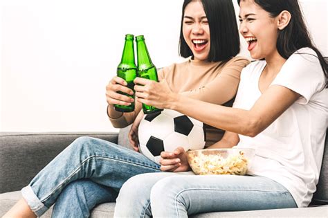 두 여자 친구 팝콘 하 고 먹고 맥주를 함께 마시는 집에서 소파에 축구 경기를 보고 우정과 파티 개념 Championship에
