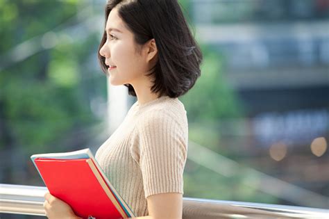 아름 다운 아시아 여성 대학생 야외 서 행복 하 게 웃는 그녀의 책을 들고 고등학교 프로그램 스마트 십 대 개념을 학습 하는