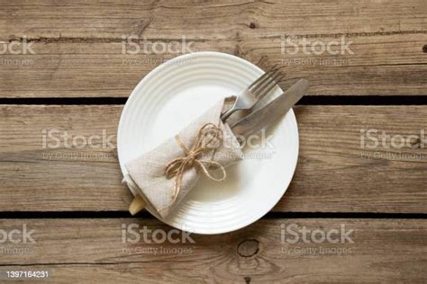 하얀 접시 하나와 칼이 달린 포크가 집 식당 사업 주방의 오래된 나무 테이블에 놓여 있습니다 0명에 대한 스톡 사진 및 기타