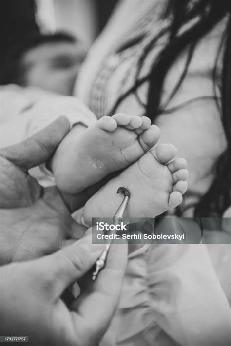 아기의 세례식 작은 아기 발의 클로즈업 세례성사 대모는 아이를 품에 안고 있다 사제는 손을 아이의 다리에 갖다 댄다 사원 정교회
