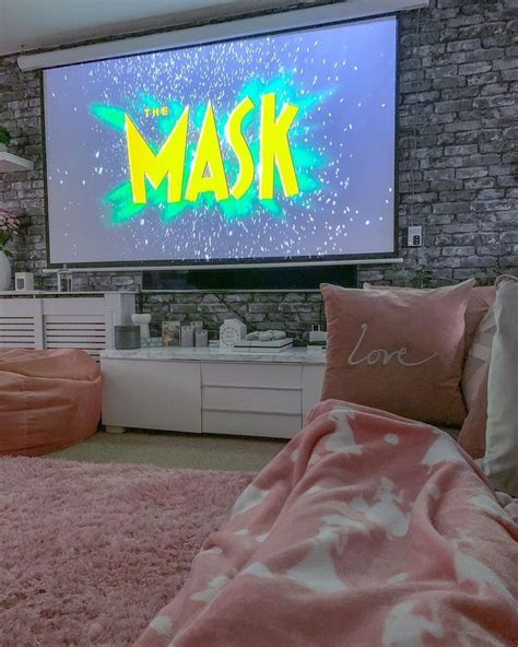 A Room With A Large Screen And Pink Bedding