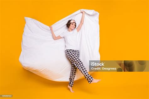 쾌활한 여성의 전체 길이 사진은 머리 위에 따뜻한 담요를 잡고 장난 기분 댄스 활기찬 착용 마스크 화이트 티셔츠 격자 무늬