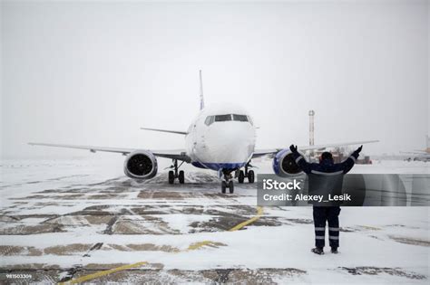 블리자드에 공항 앞치마에 지상 승무원 공원 현대 여객 정기 여객기의 에이전트 회원 겨울 폭설에 공항에서 여객 정기 여객기 택시