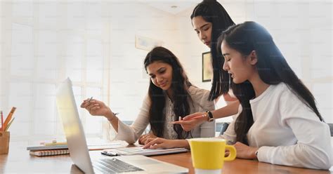 그래픽 디자이너 회의브레인스토밍은 커피 컵과 사무 기기로 둘러싸인 나무 작업 책상에 올려놓는 컴퓨터 노트북을 사용합니다 사진 Unsplash의 테이블 이미지