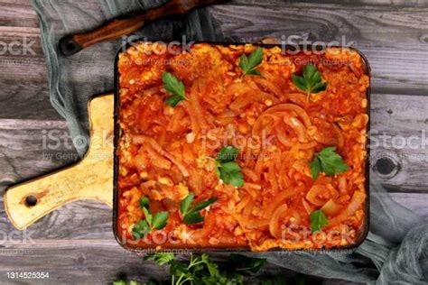 토마토 소스와 양파를 유리 그릇에 넣고 구운 청어 생선을 반죽합니다 토마토 소스에 야채와 함께 구운 생선 0명에 대한 스톡 사진