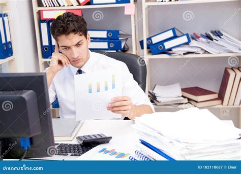 Businessman Working In The Office With Piles Of Books And Papers Stock