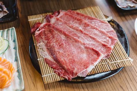 레어의 상위 뷰 샤 수프 뜨거운 남 비에서 비등에 대 한 검은 접시와 대나무 매트에 Wagyu A5 쇠고기 조각 개성 개념에
