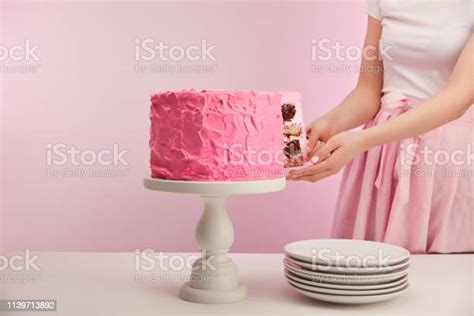핑크에 화이트 접시 근처의 분홍색 생일 케이크를 복용 하는 여자의 자른 보기 단일 이미지에 대한 스톡 사진 및 기타 이미지