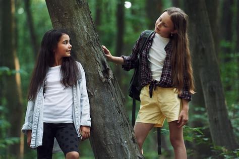 Premium Photo Standing And Looking At Each Other Two Girls Is In The