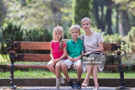 젊은 어머니와 두 아이 소년과 소녀 여름 공원에서 벤치에 함께 즐거운 시간을 보내고 가족에 대한 스톡 사진 및 기타 이미지 가족 공원 공원 벤치 Istock