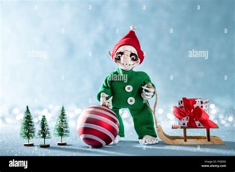 Cute Smiling Santas Helper Elf Holding Christmas Bauble And Pulling
