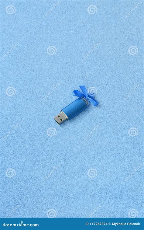 Brilliant Blue Usb Flash Memory Card With A Blue Bow Lies On A Blanket