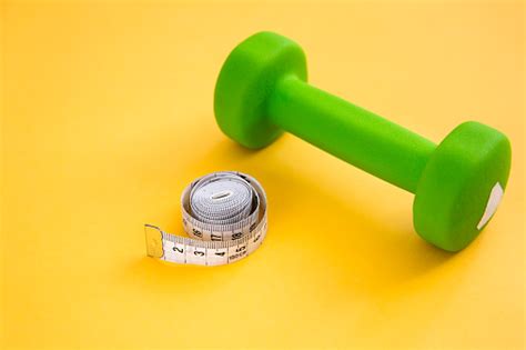 다이어트 체중 감소 및 과체중 개념 노란색 배경에 아령 및 측정 테이프 텍스트에 배치합니다 0명에 대한 스톡 사진 및 기타