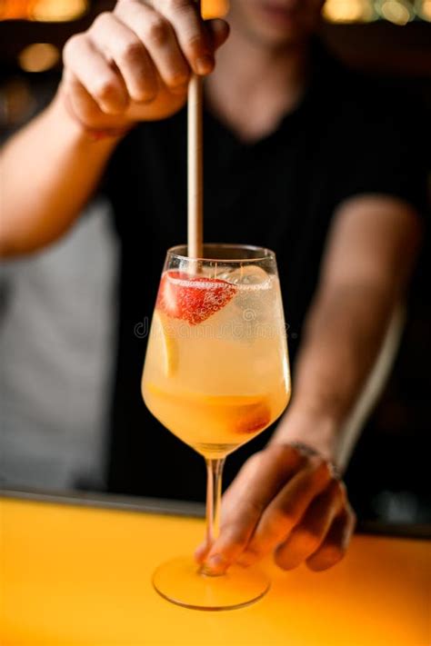 Focus On Glass Of Fizzy Cocktail Which Hand Of Male Bartender Stirs