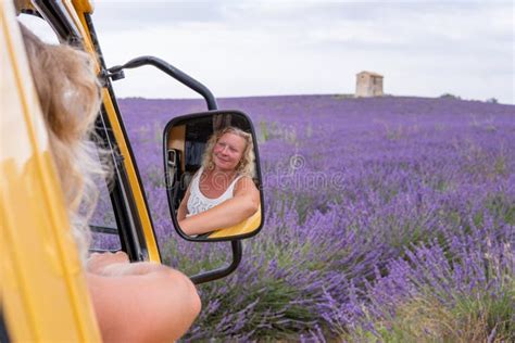 Car Mirror Reflection Of A Young Smiling Blonde Woman Enjoying The View