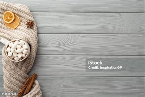 겨울 미적 개념입니다 마시멜로 니트 스카프 말린 오렌지 슬라이스 아니스와 계피 스틱으로 뜨거운 음료의 머그잔의 상위 뷰 사진 복사 공간이 있는 회색 나무 책상 배경 0명에