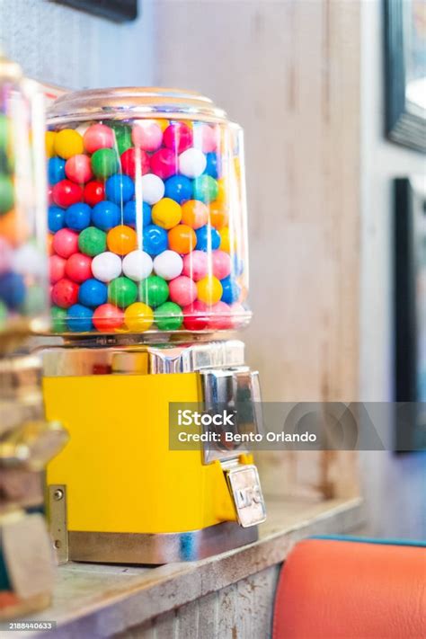 향수를 불러일으키는 분위기의 활기찬 검볼 머신은 유리 내부에 전시된 다채로운 구체의 폭발을 제공하여 복고풍 스타일의 환경에서 사탕 애호가에게 어린 시절의 추억과 즐거움을