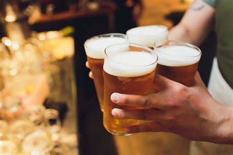 웨이터는 바 나 술집에서 손에 맥주 4 잔을 들고있다 맥주 잔 Ale에 대한 스톡 사진 및 기타 이미지 Ale 국가 관광