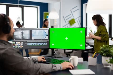 Free Photo Videographer Using Computer With Chroma Key Mock Up Isolated Display Editing Video