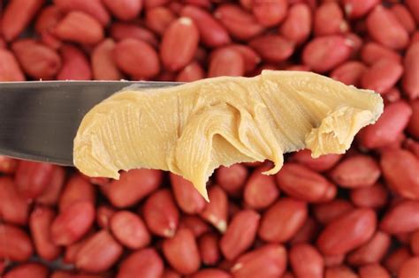 Premium Photo Delicious Peanut Butter On Knife On Peanuts Background