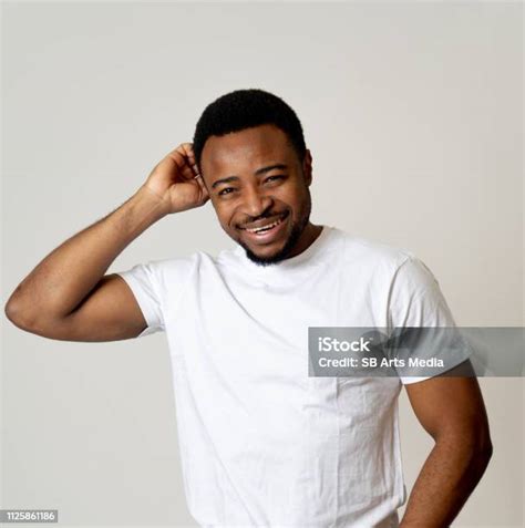 포즈와 카메라 보고 아름 다운 미소로 유혹 하는 행복 한 얼굴로 매력적인 부끄러워 젊은 아프리카계 미국인 남자의 반 길이 초상화 긍정적인 감정을 사람과 인간의 얼굴 표정