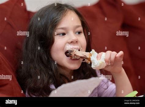 Expressive Young Girl Is Eating Chicken And Vegetables For Dinner On
