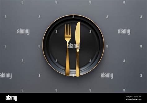 Gold Knives And Forks On A Black Background Empty Black Plate