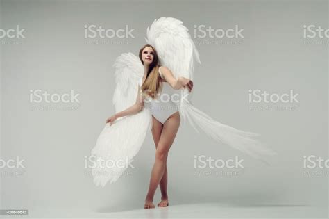 하얀 날개를 들고 일어선 포즈를 취하는 낭만적 인 천사 소녀 공연에 대한 스톡 사진 및 기타 이미지 공연 귀여운 날개달린