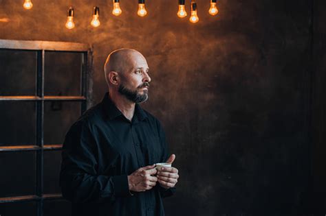 검은 셔츠를 입은 슬픈 심각한 중년 남자는 어두운 벽이있는 방에서 자신의 문제에 대해 생각합니다 40 49세에 대한 스톡 사진 및 기타 이미지 Istock