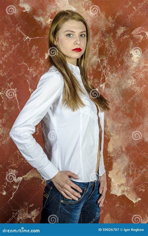 Jonge Slanke Mooie Jonge Blonde Vrouw Met Lange Benen En Haar In Tumultoverhemd En Jeans Stock