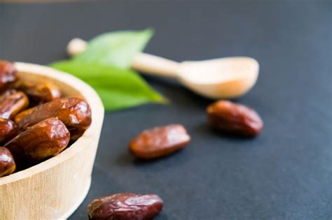 근접 촬영 달콤한 말린 대추 과일 또는 Kurma 라마단 음식 자연 빛입니다 선택적 초점입니다 검은 배경에 닫습니다 상위 뷰