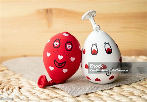 풍선으로 만들고 밀가루로 채워진 두 개의 재미있는 수제 감각 스트레스 볼 빨간색과 흰색 공은 하트와 재미있게 그려진 얼굴 나무 배경입니다 풍선에 대한 스톡 사진 및 기타