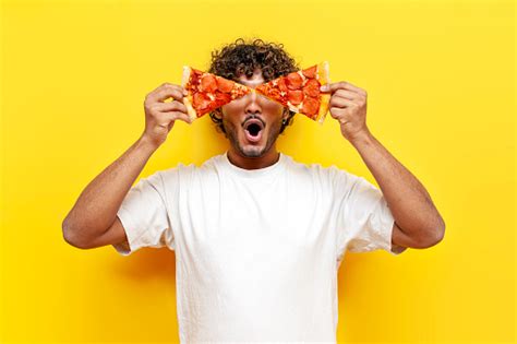 배고픈 힌두교 남자가 맛있는 피자 두 조각을 들고 노란색 고립 된 배경에 놀랐습니다 20 24세에 대한 스톡 사진 및 기타 이미지 20 24세 건강에 좋지 않은 음식