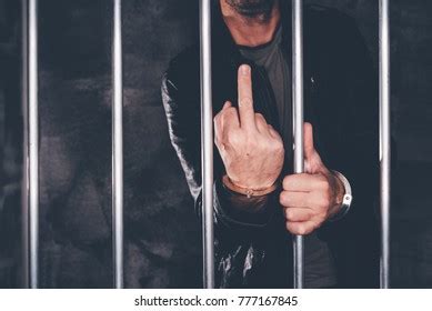 Handcuffed Man Behind Prison Bars Giving Stock Photo 777167845